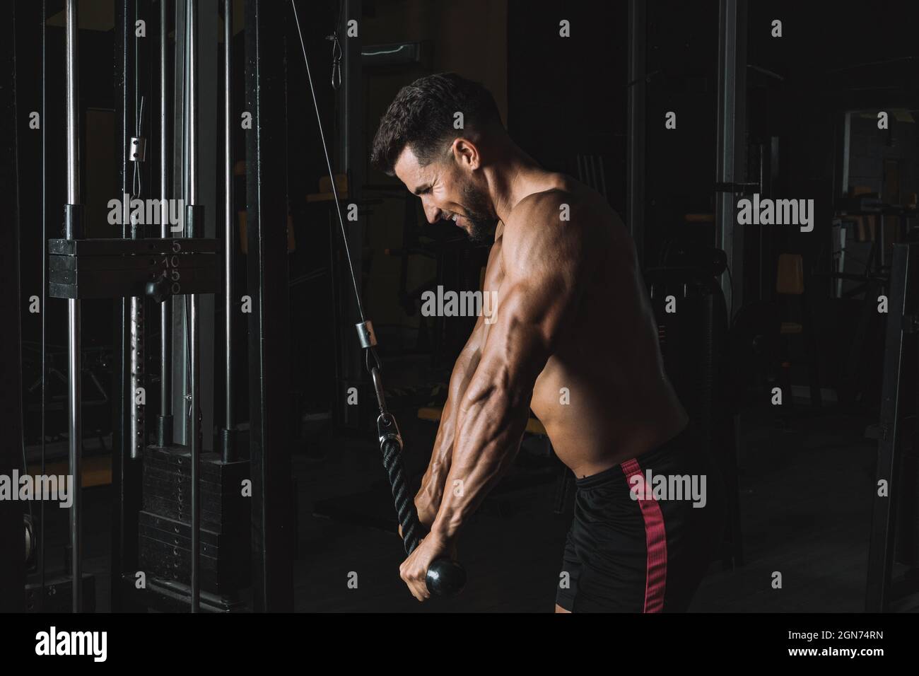 Strong man pulling from a weigh machine in a gym Stock Photo - Alamy