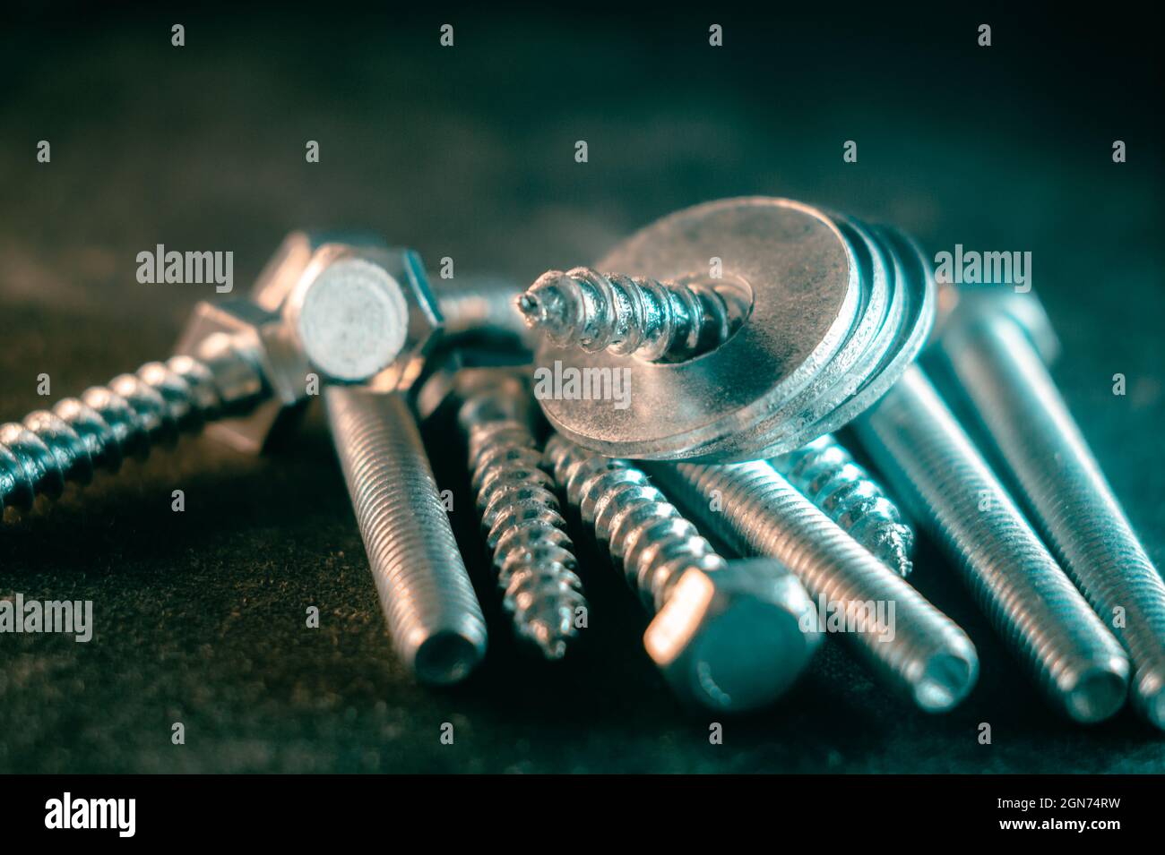 Pile of screws on a black background Stock Photo - Alamy