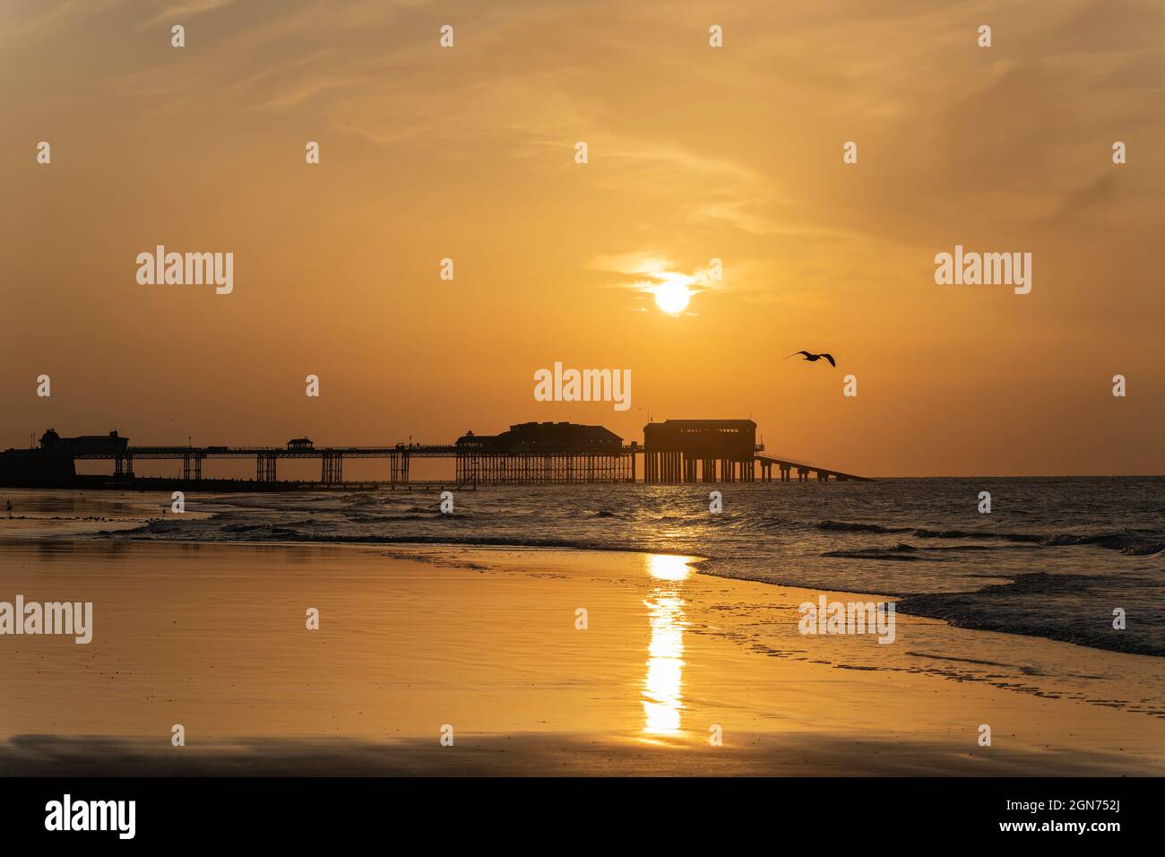 view of sunset over Cromer pier showing the end of the pier theatre and ...