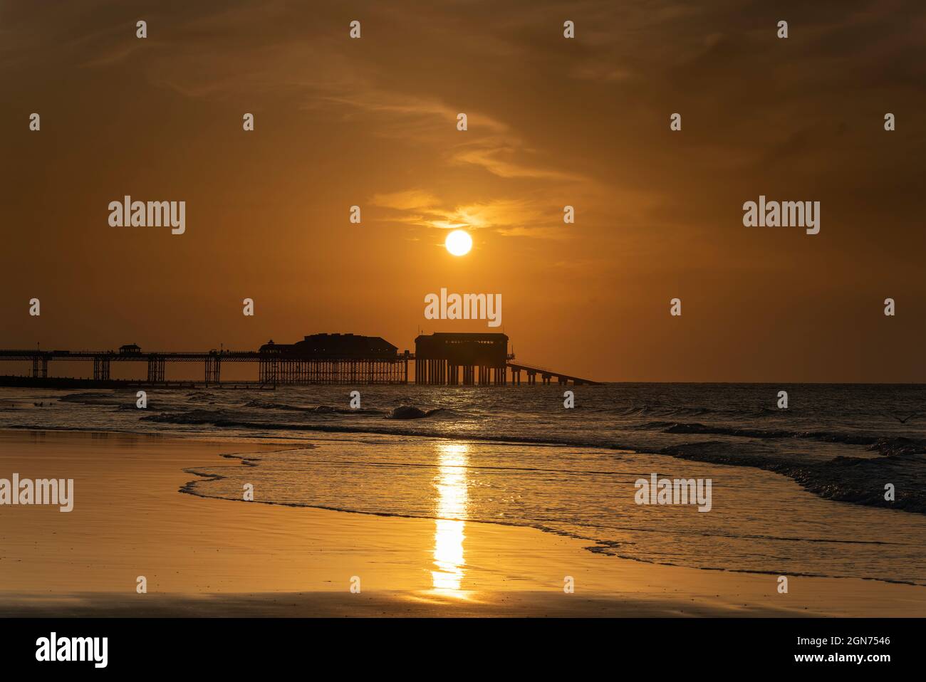 view of sunset over Cromer pier showing the end of the pier theatre and ...