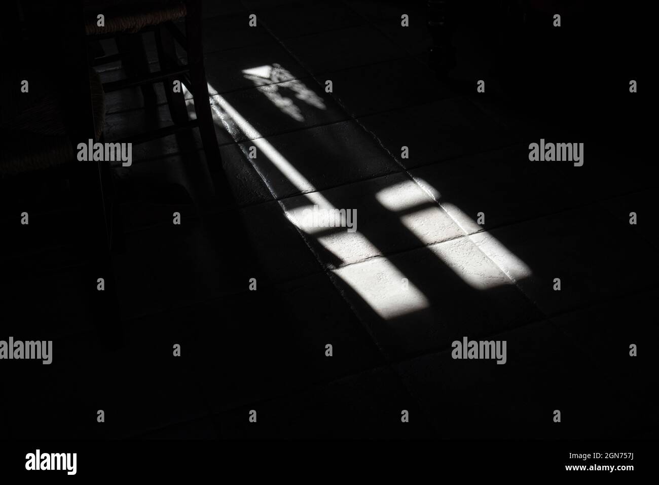 Light cast through window on stone floor with long nice sharp shadow ...