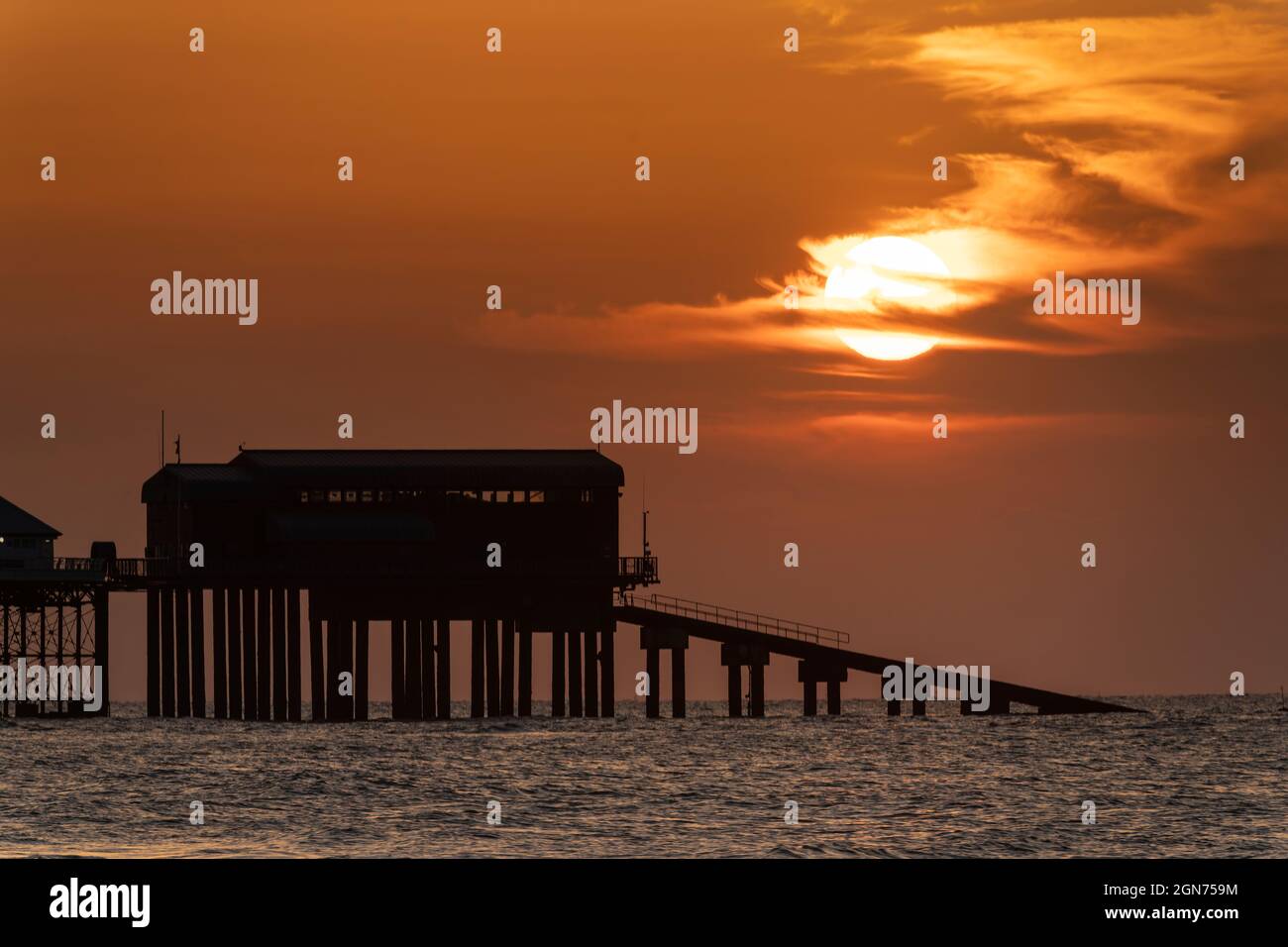view of sunset over Cromer pier showing the end of the pier theatre and ...