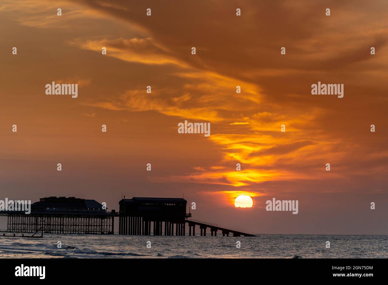 view of sunset over Cromer pier showing the end of the pier theatre and ...