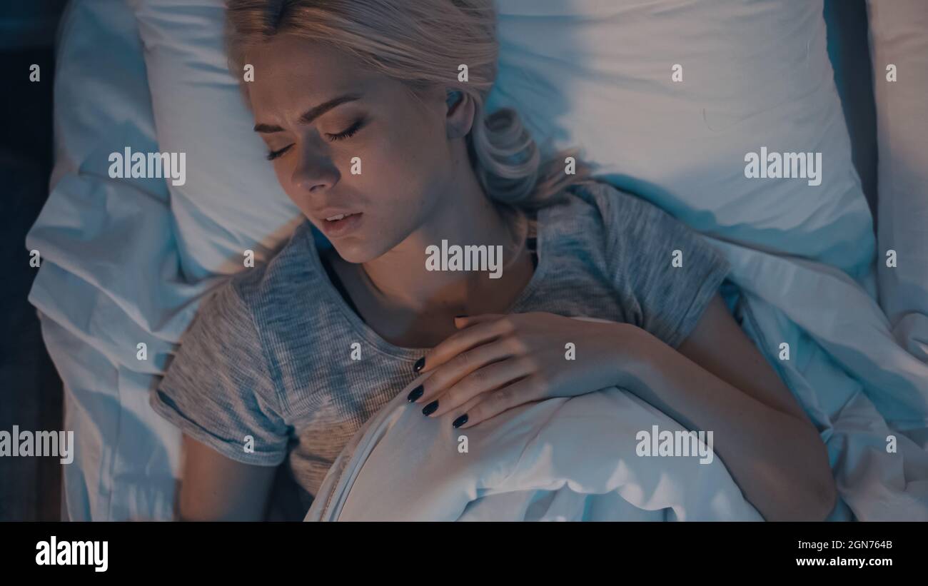 Top view of blonde woman sleeping on bed at night Stock Photo - Alamy