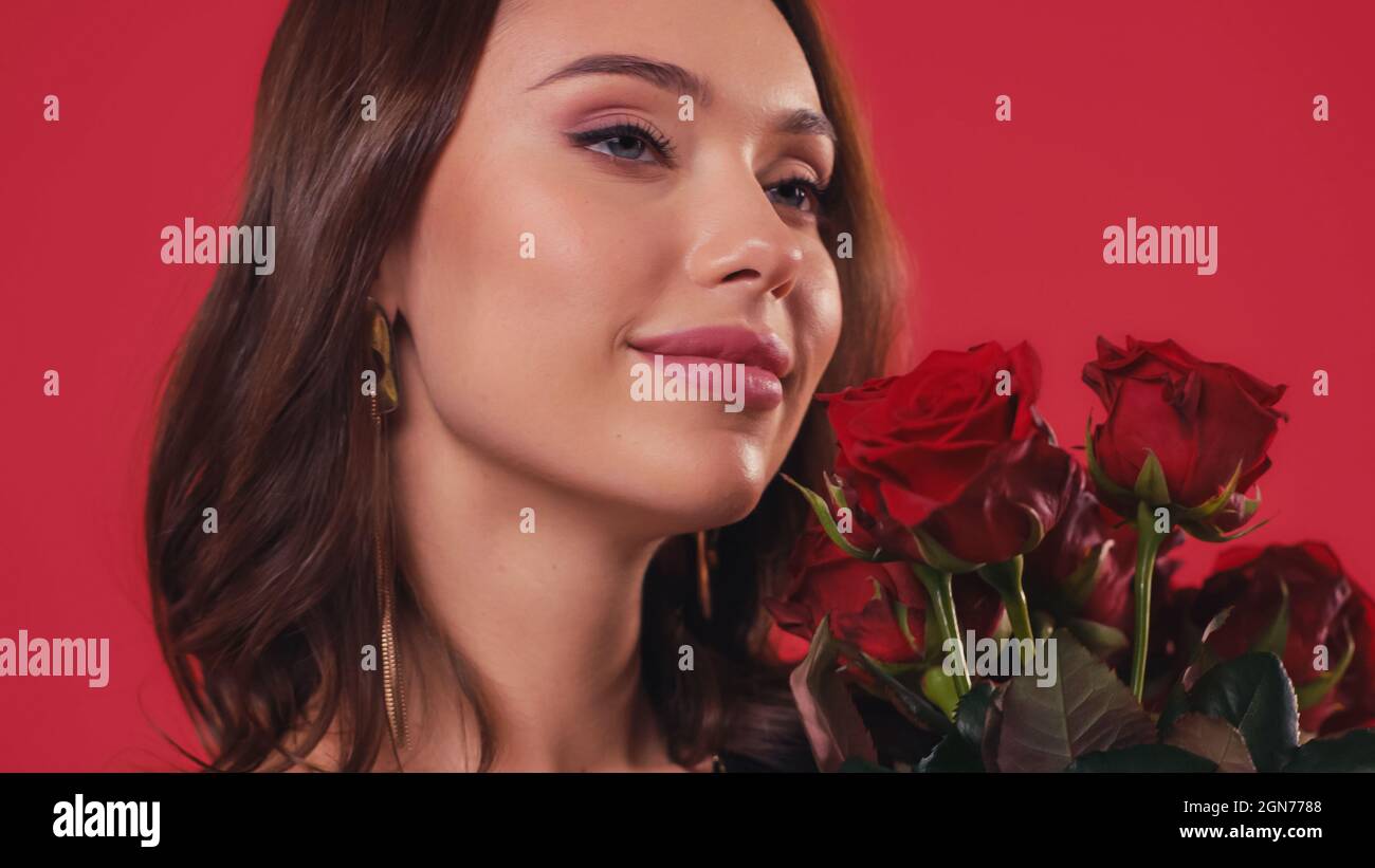 Woman smelling on red roses hi-res stock photography and images - Alamy