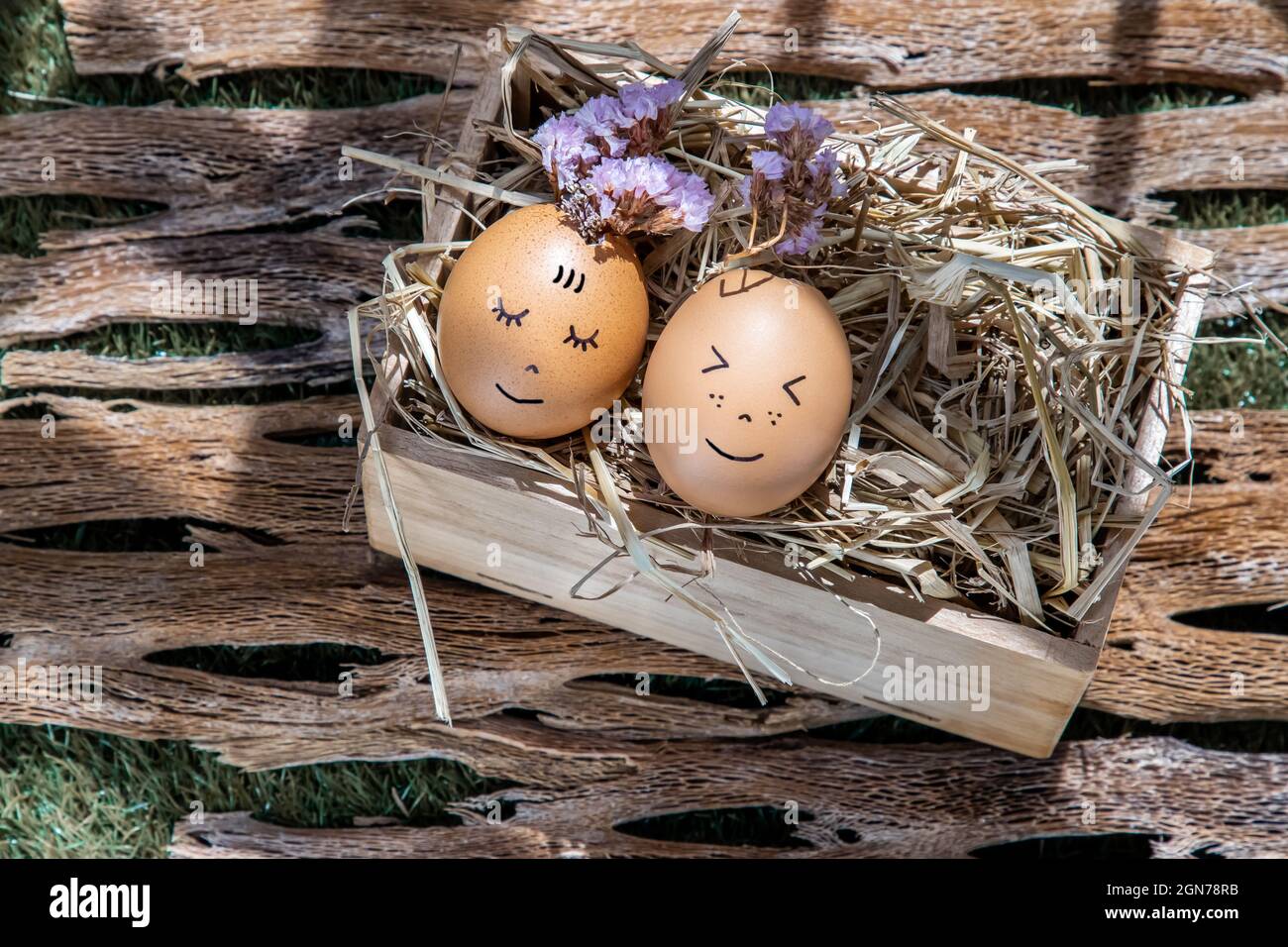 The two happy eggs is lying on dry straw. Happy and relaxing concept ...