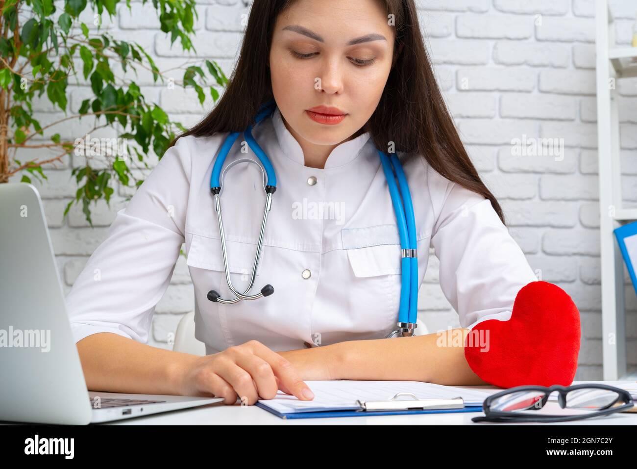 Brunette Female Doctor Working At Her Table In Hospital Close Up Stock
