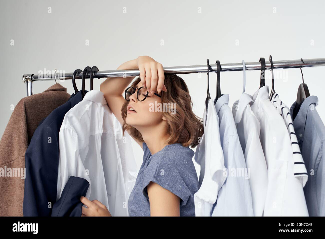 pretty woman selection of clothes near the wardrobe light background ...