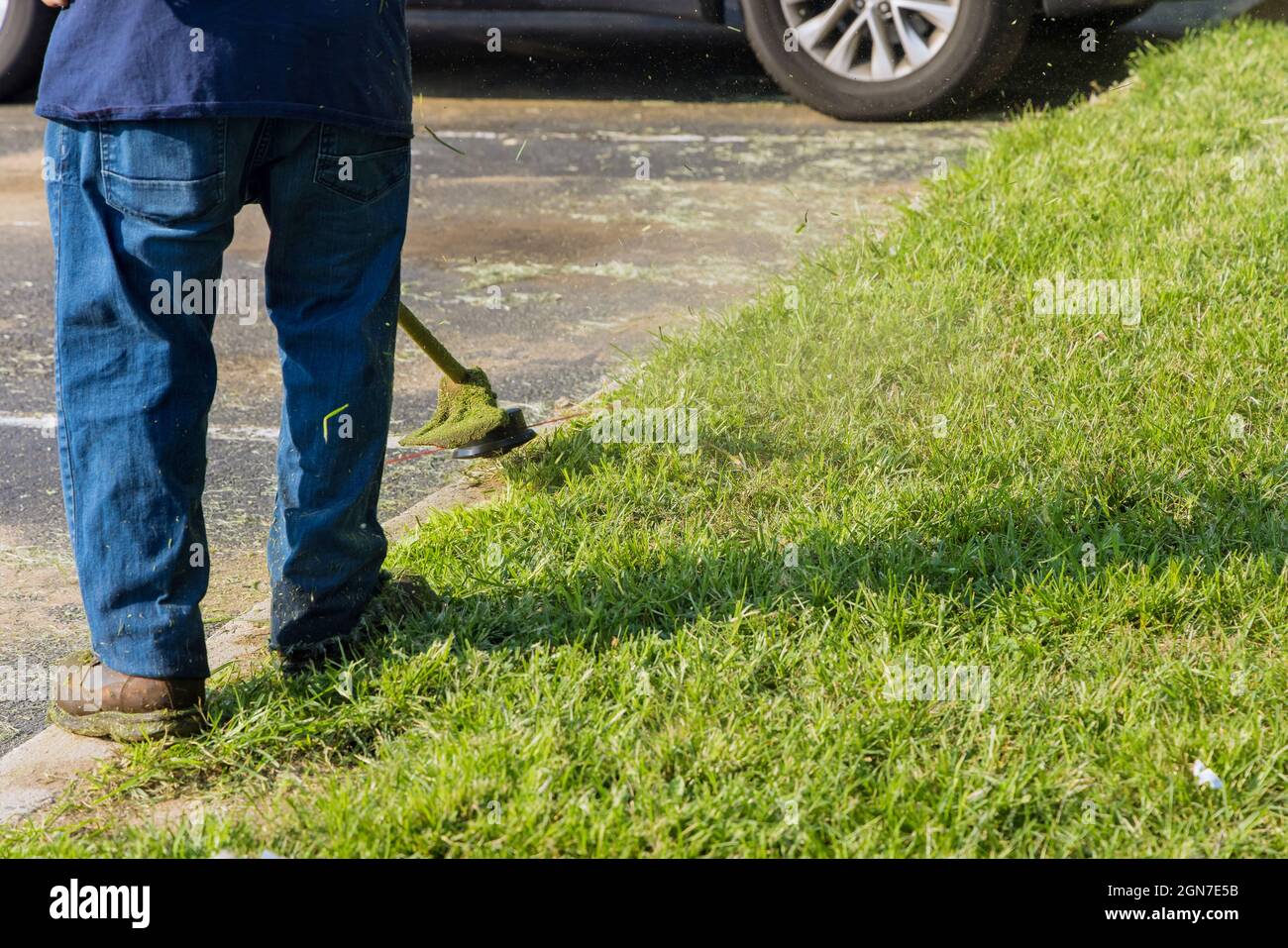 Municipal worker using mower mowing the grass in roadside Stock Photo ...
