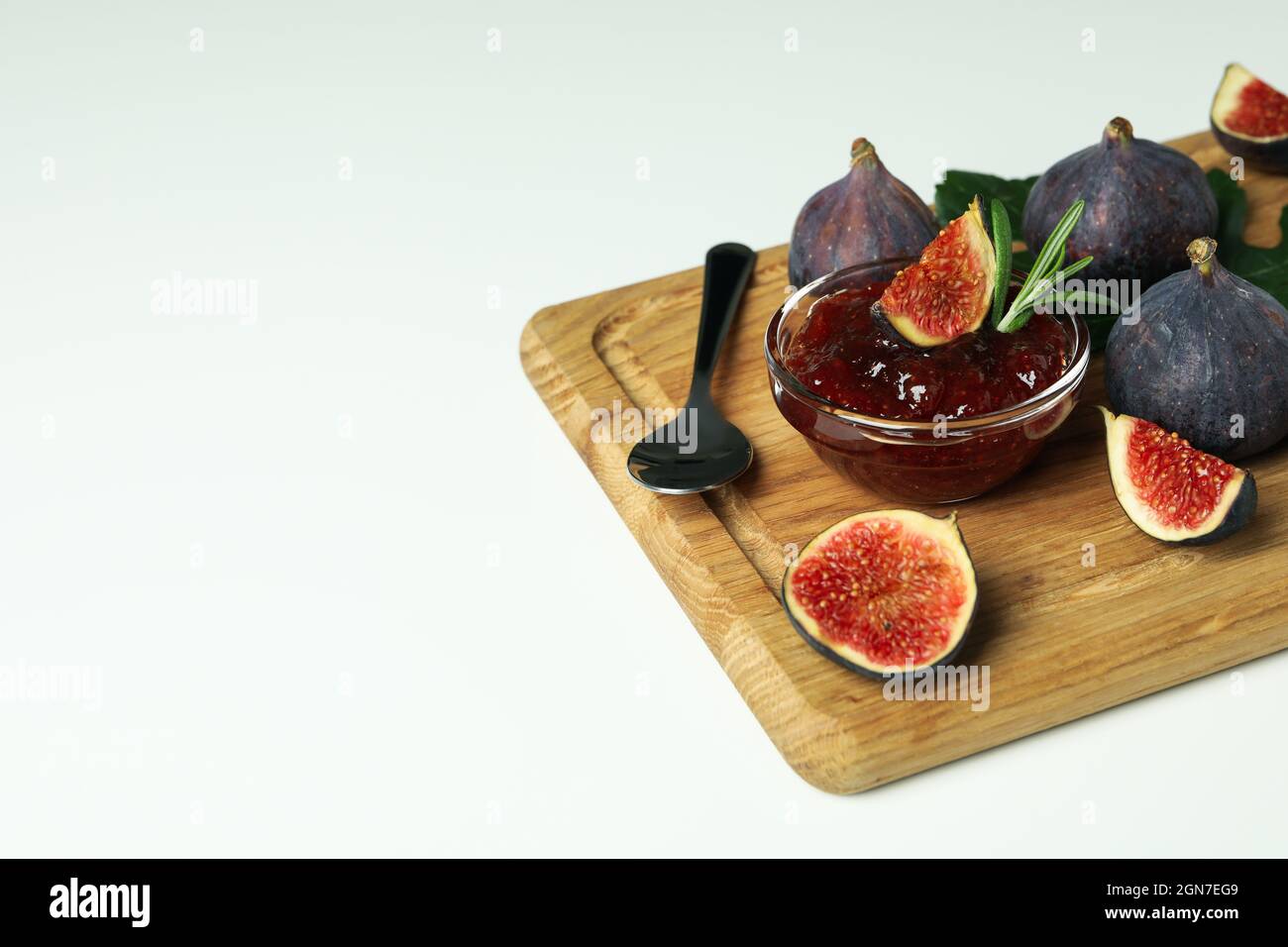Board with fig jam, ingredients and spoon on white background Stock ...