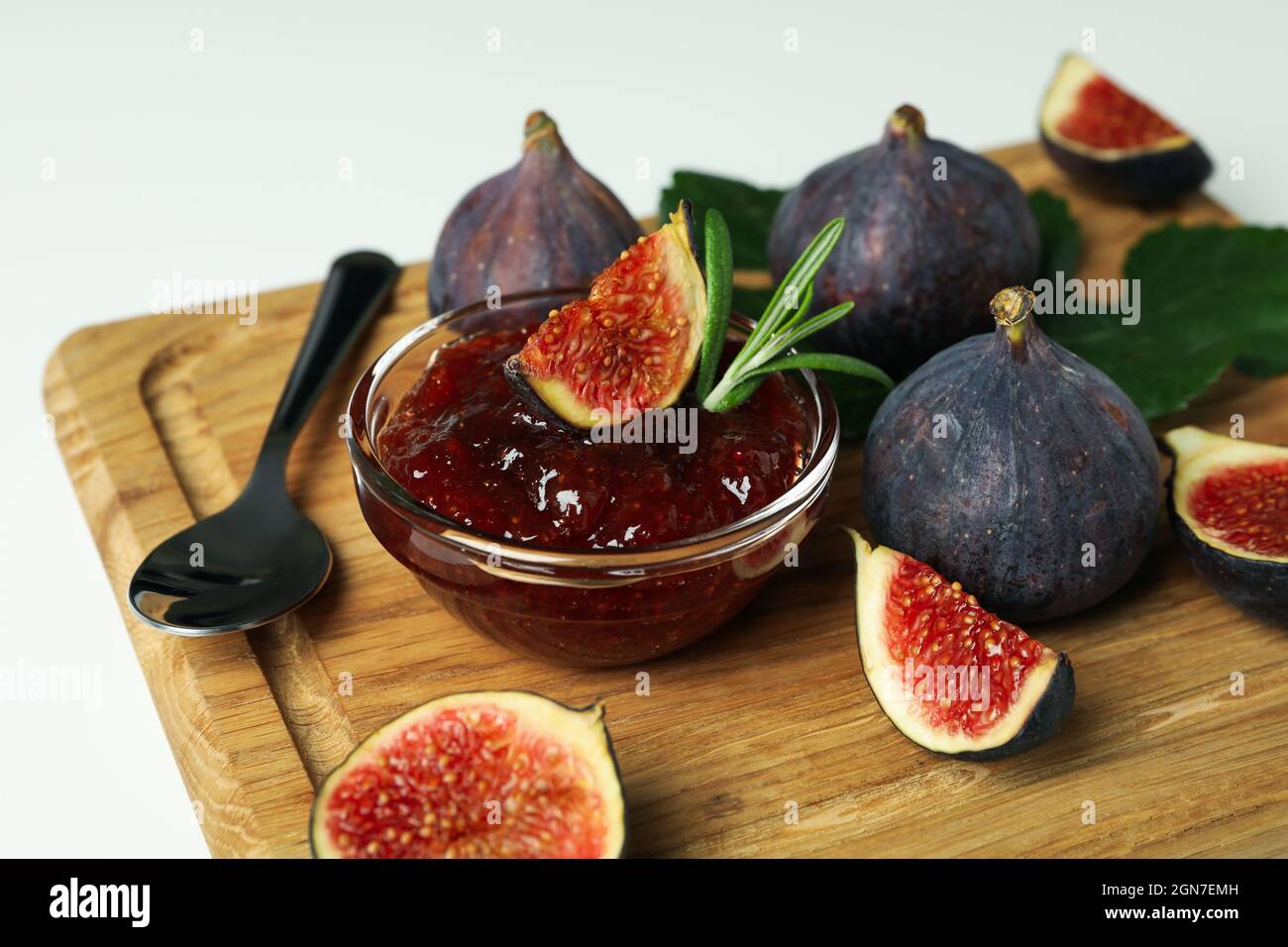 Board with fig jam, ingredients and spoon on white background Stock ...