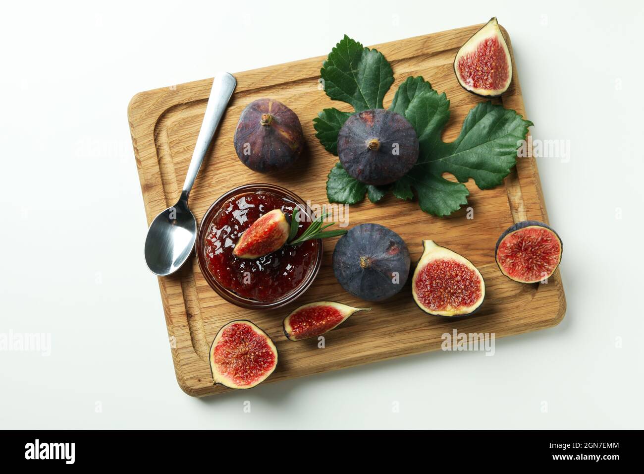 Board with fig jam, ingredients and spoon on white background Stock ...