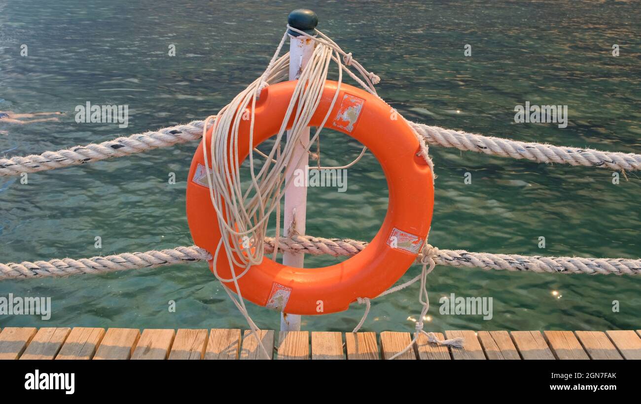 Orange lifeline and sea ropes on the background of the sea and blue sky ...
