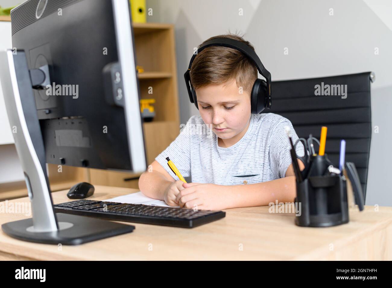 Primary school male student studying on the distance. Little boy in ...