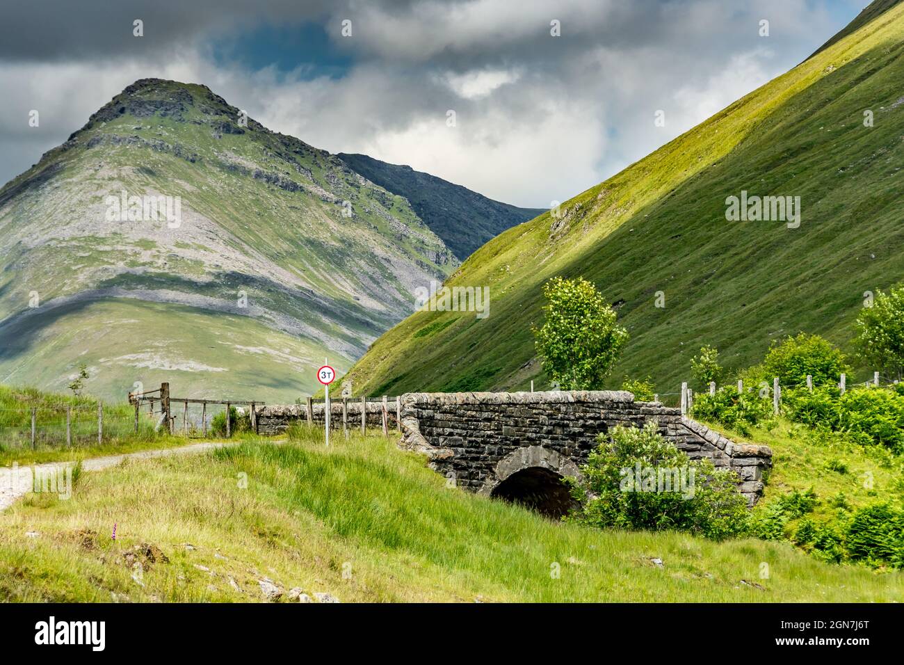 Along the West highland Way in Scotland. An old stone bridge spans the ...