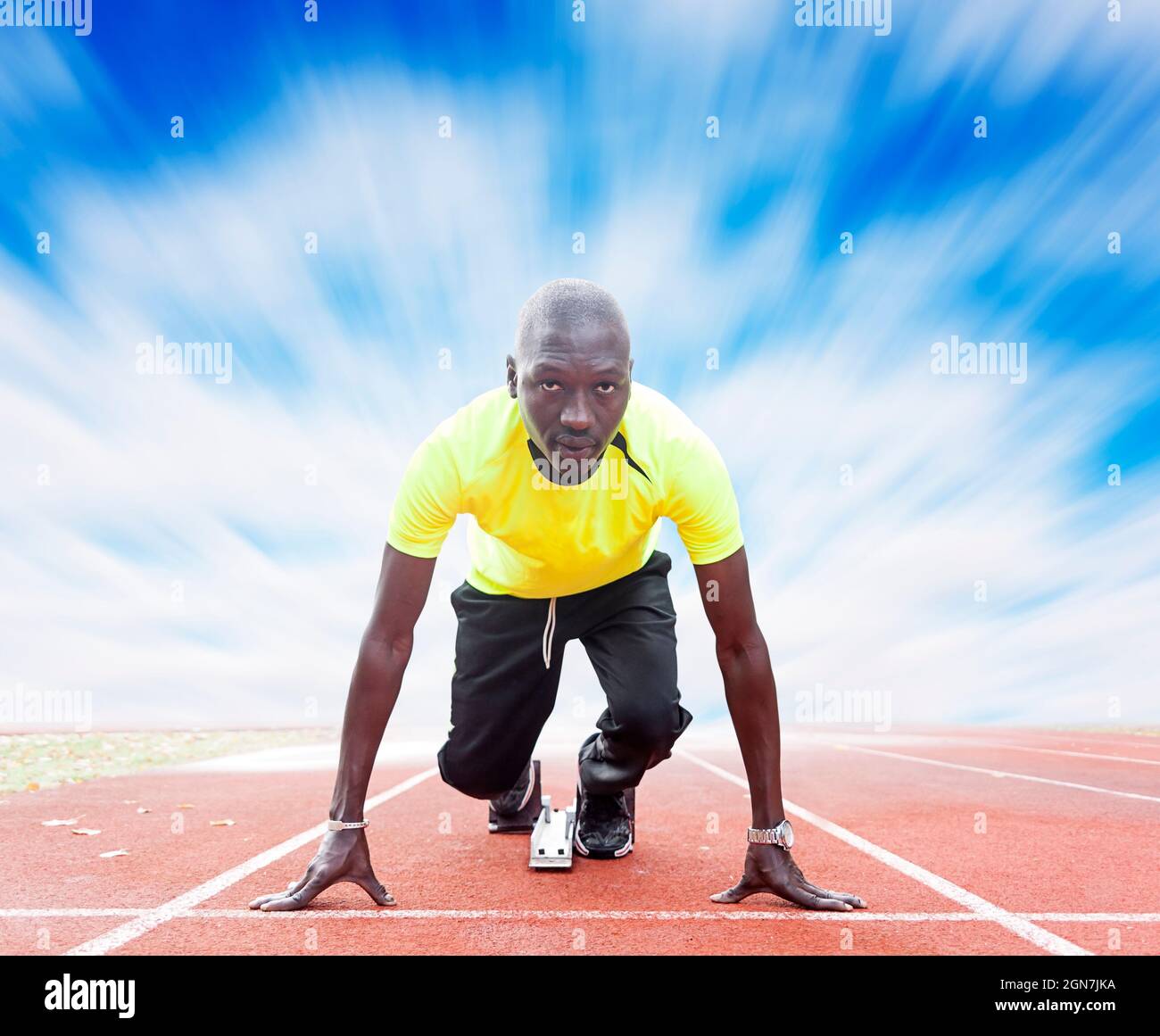 african american athlete sprinter on the starting blocks under cloudy ...