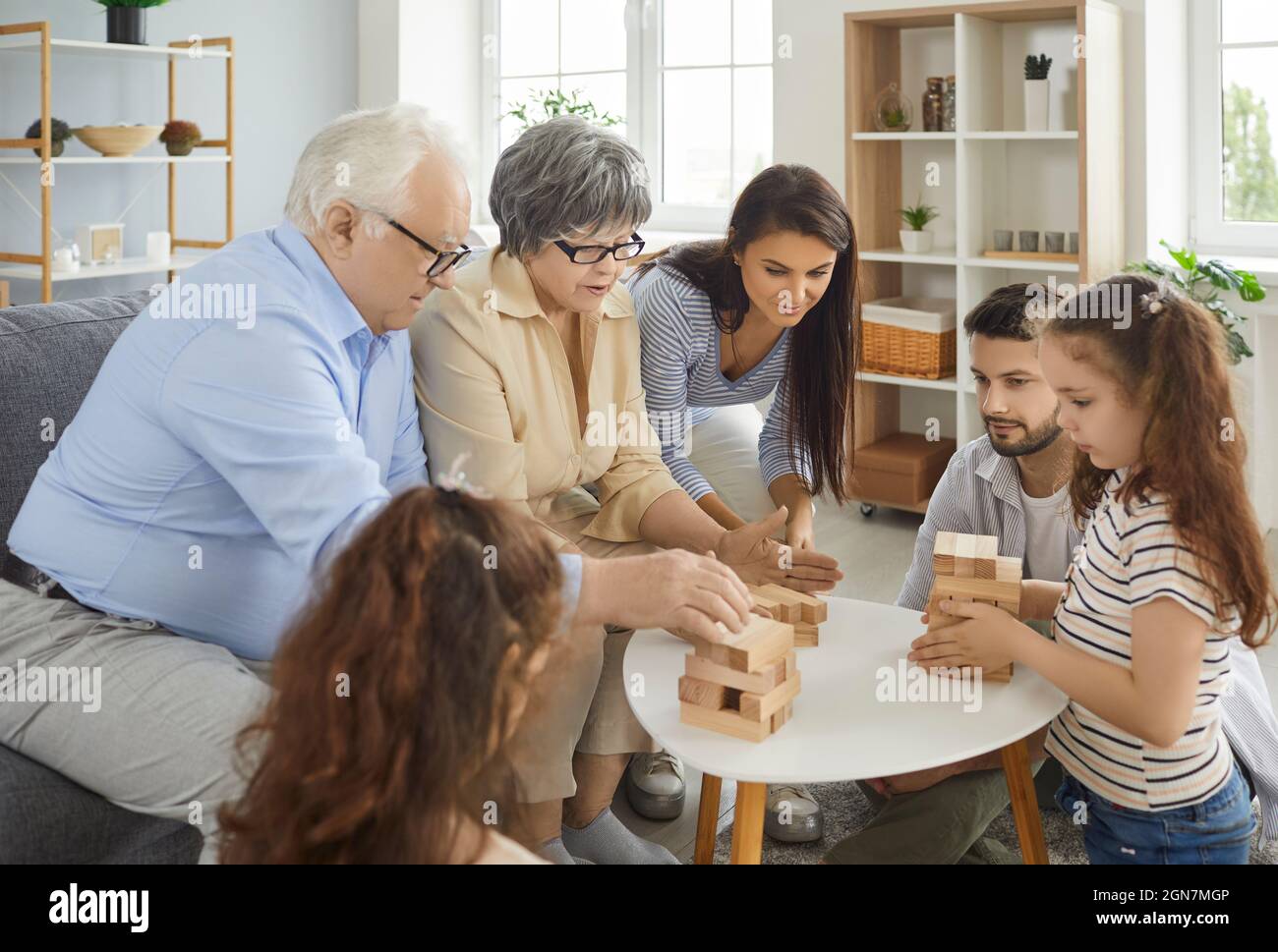 Large family of different generations concentrate on a wooden brick ...