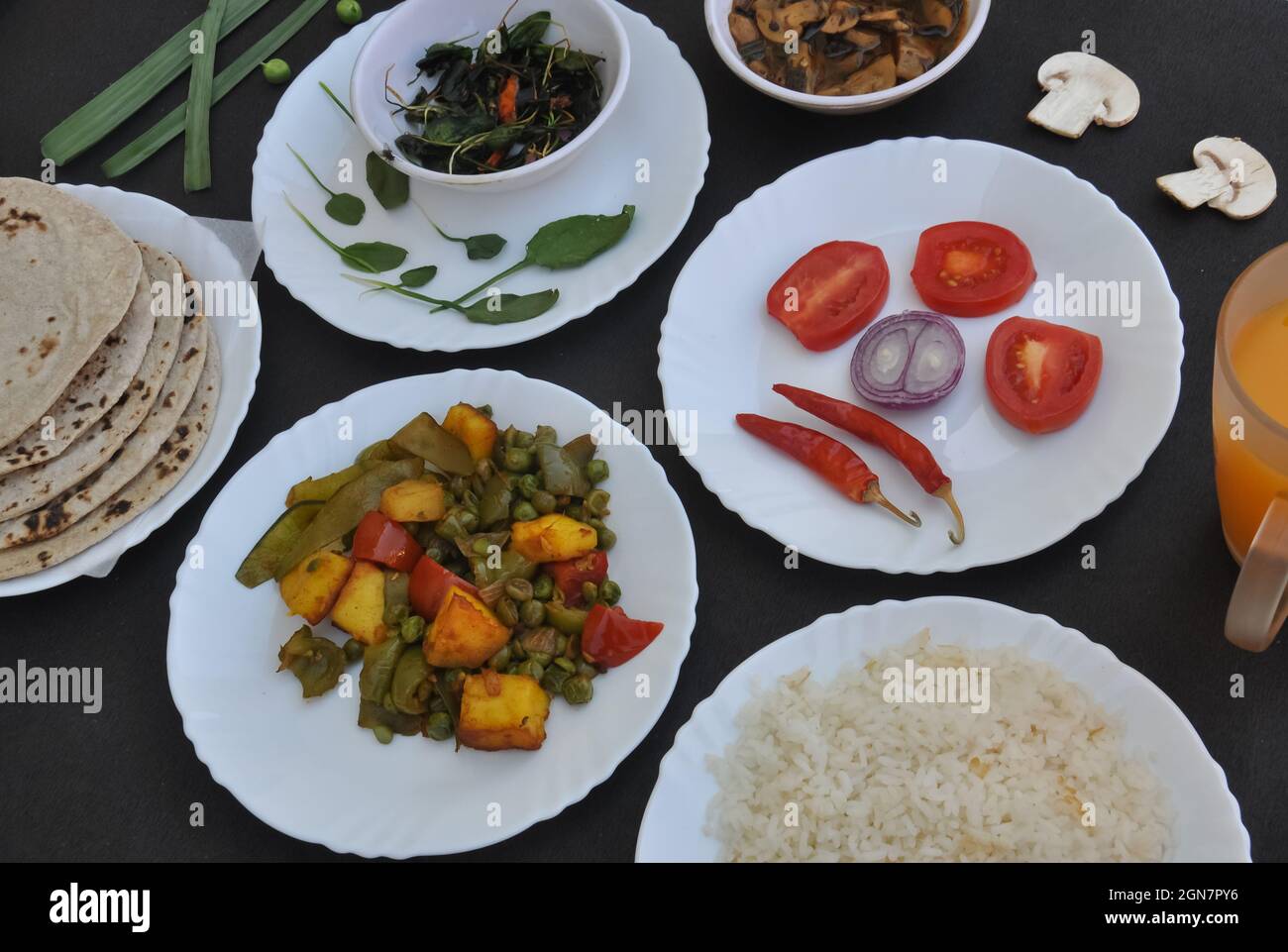 Indian Food: Flat lay of mushroom soup, saag (greens), salad, chapati ...