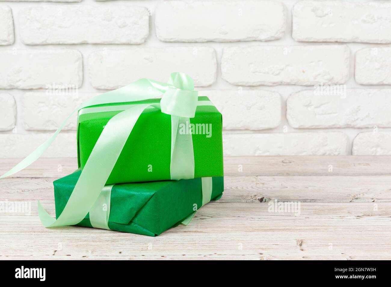 Colorful gift boxes against white brick wall background Stock Photo - Alamy