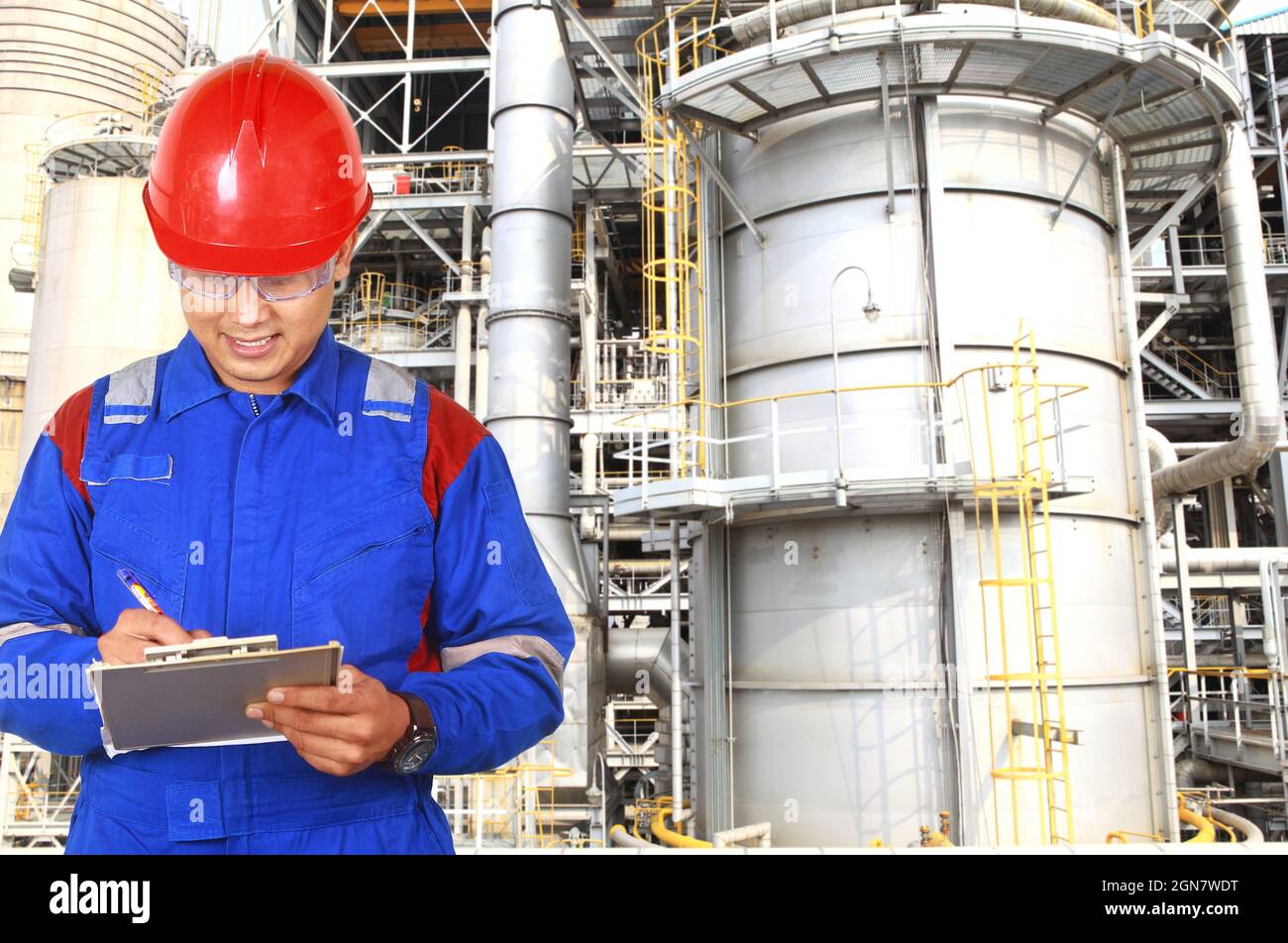 Engineer checking on note pad in front of the natural gas pipes ...