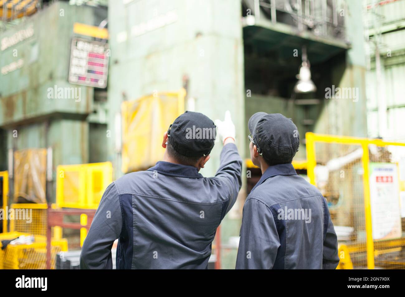 Industrial engineers pointing while discussing about problem machine ...