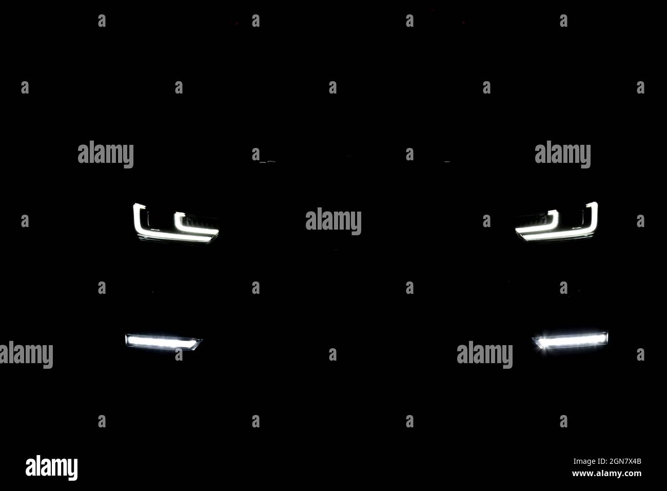 laser headlights and fog lights of a modern car glow in the dark ...