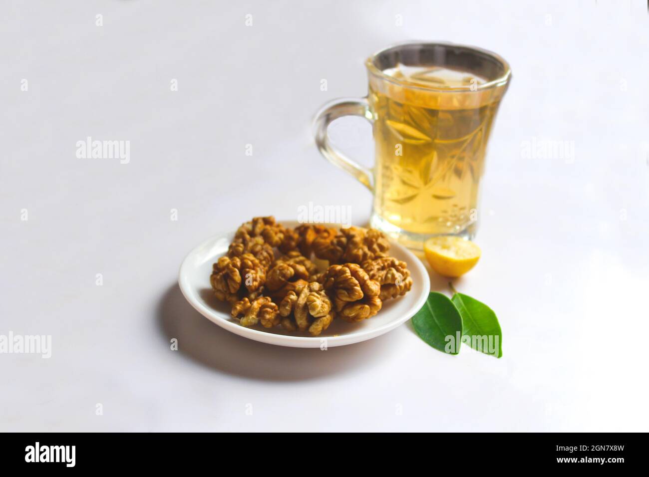 walnut and green tea with lemon leaves isolated on white background ...