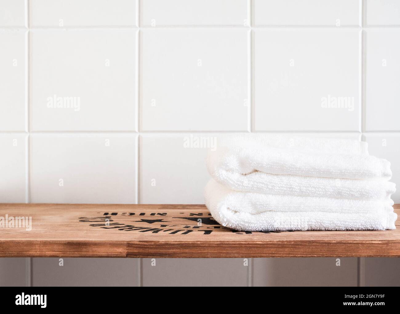 Bath background front view with white towels on brown wood shelf and ...