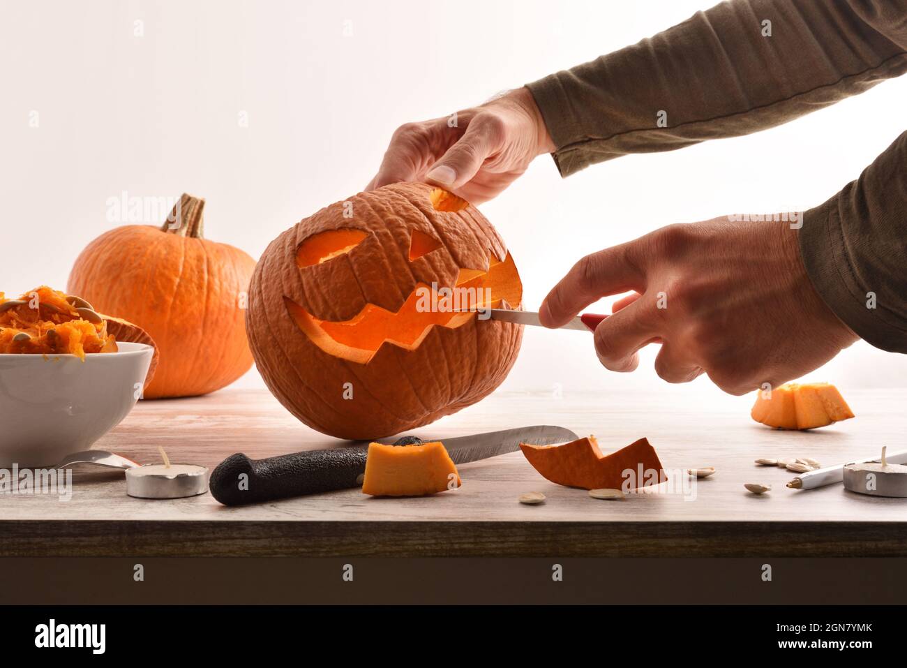 Detail of man carving and emptying a pumpkin for the halloween party ...