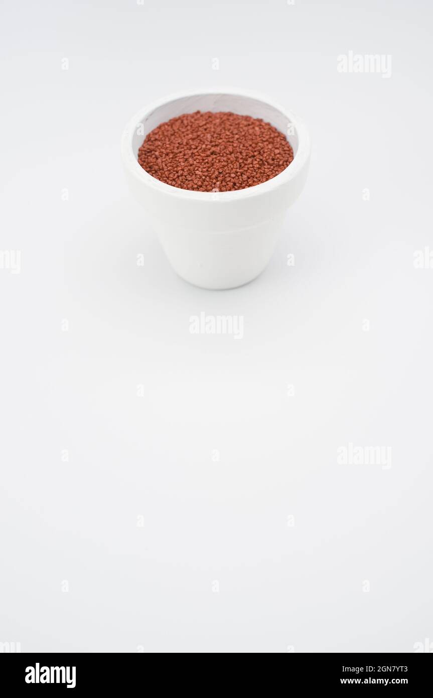 decorative orange colored sand in a white vase Stock Photo - Alamy