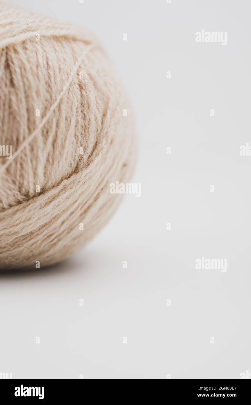 Vertical shot of soft beige yarn balls on a white background Stock ...