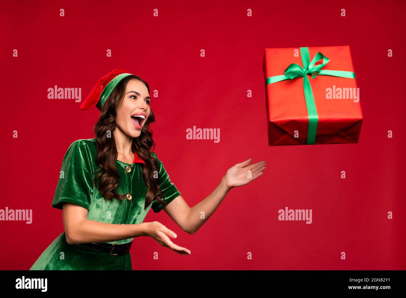 Photo portrait female elf smiling throwing present in air isolated ...