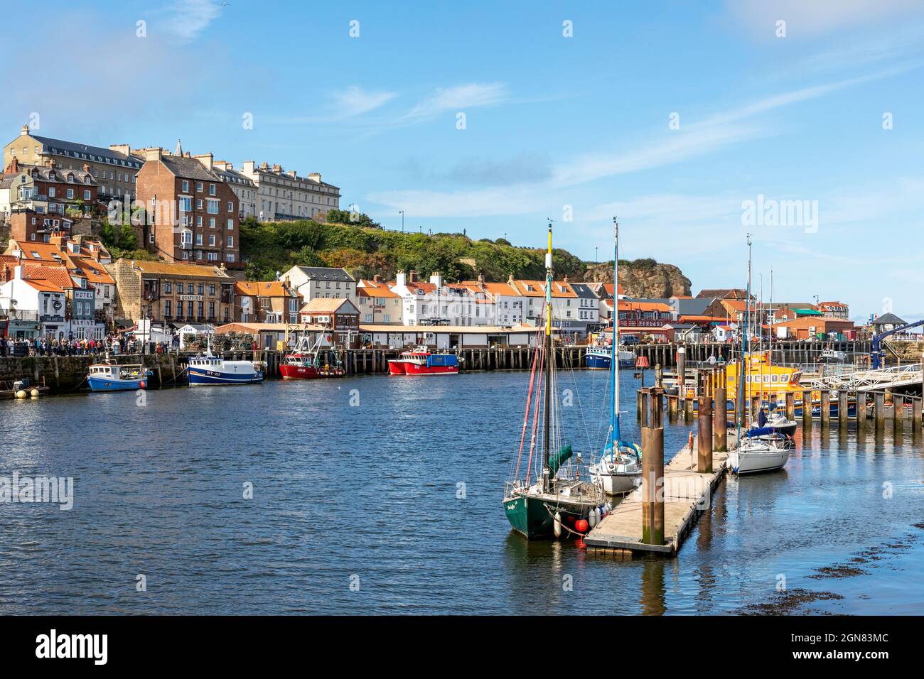 View of Whitby harbour showing fishing boats and private yachts in the ...