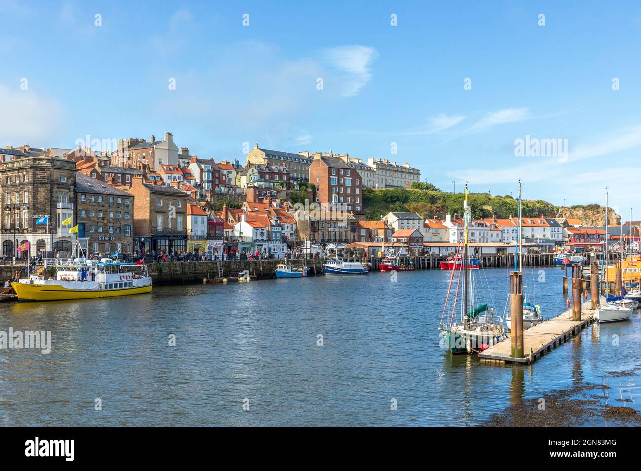 View of Whitby harbour showing fishing boats and private yachts in the ...