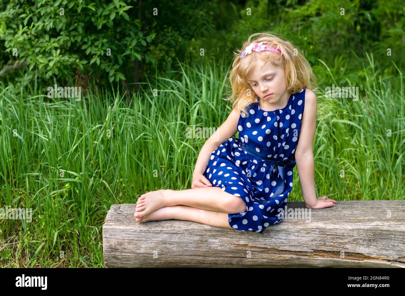 beautiful sad blond girl sitting in bench Stock Photo - Alamy