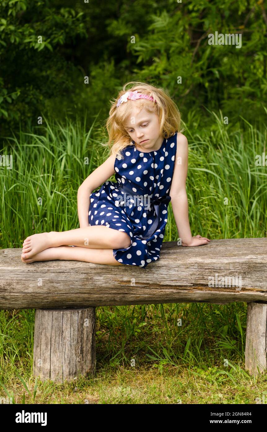 beautiful sad blond girl sitting in bench Stock Photo - Alamy