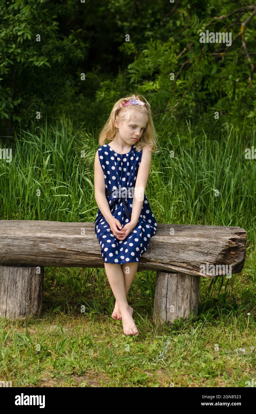 blond girl sitting on bench Stock Photo - Alamy