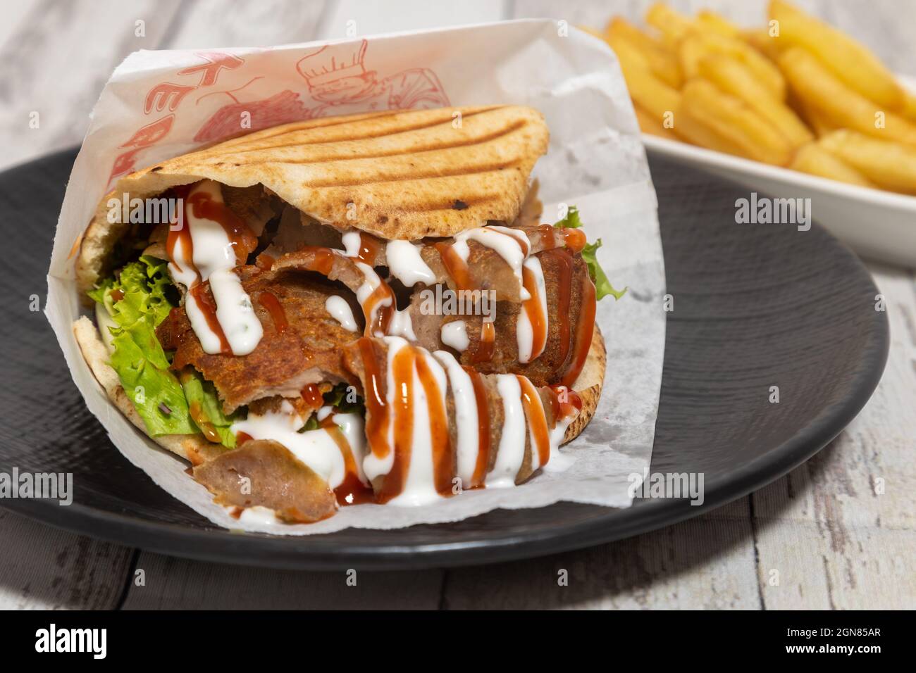 Closeup of delicious gyros with fries on the wooden table Stock Photo ...