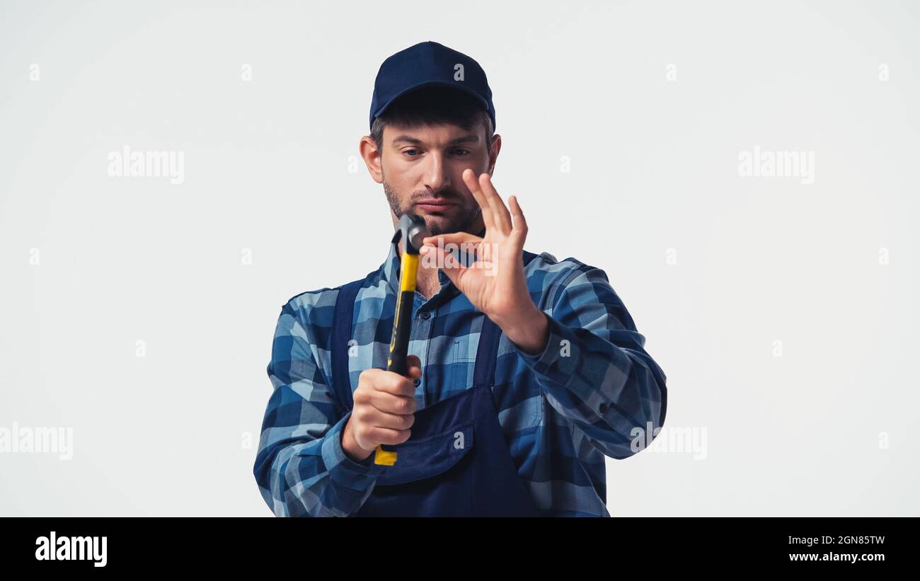 Handyman in overalls holding hummer isolated on white Stock Photo - Alamy
