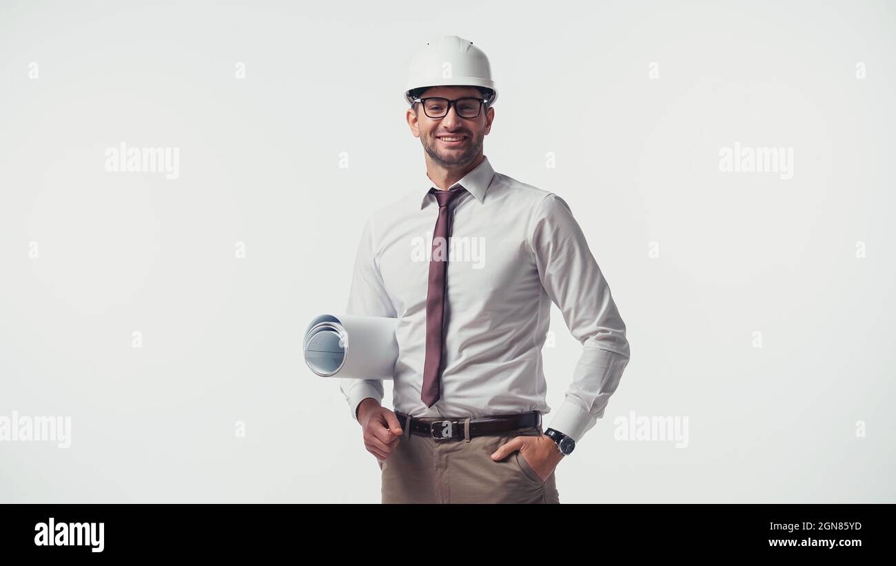 Smiling engineer with blueprint looking at camera isolated on white ...