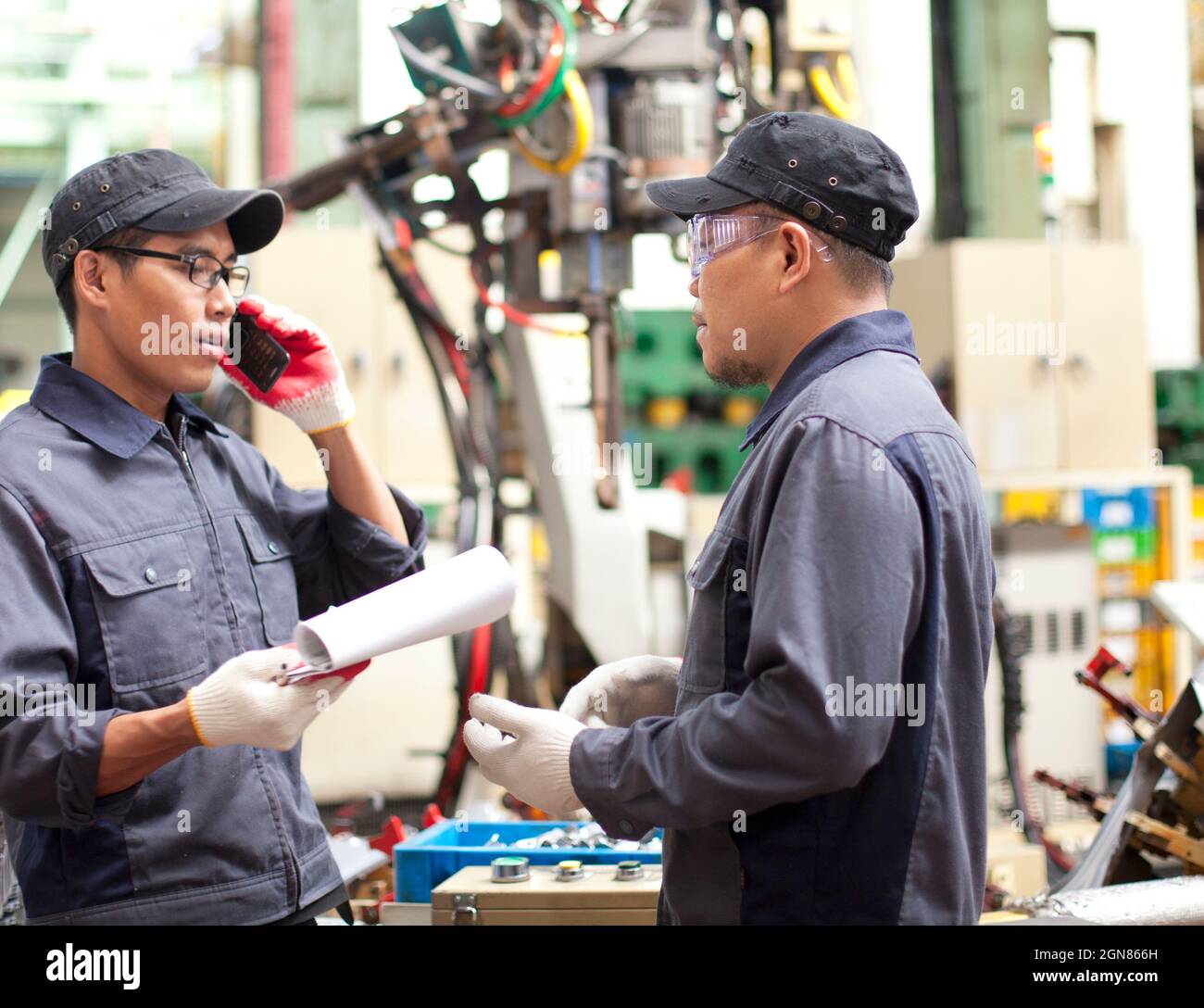 Two technician in a factory talking how repair a robot machine Stock ...