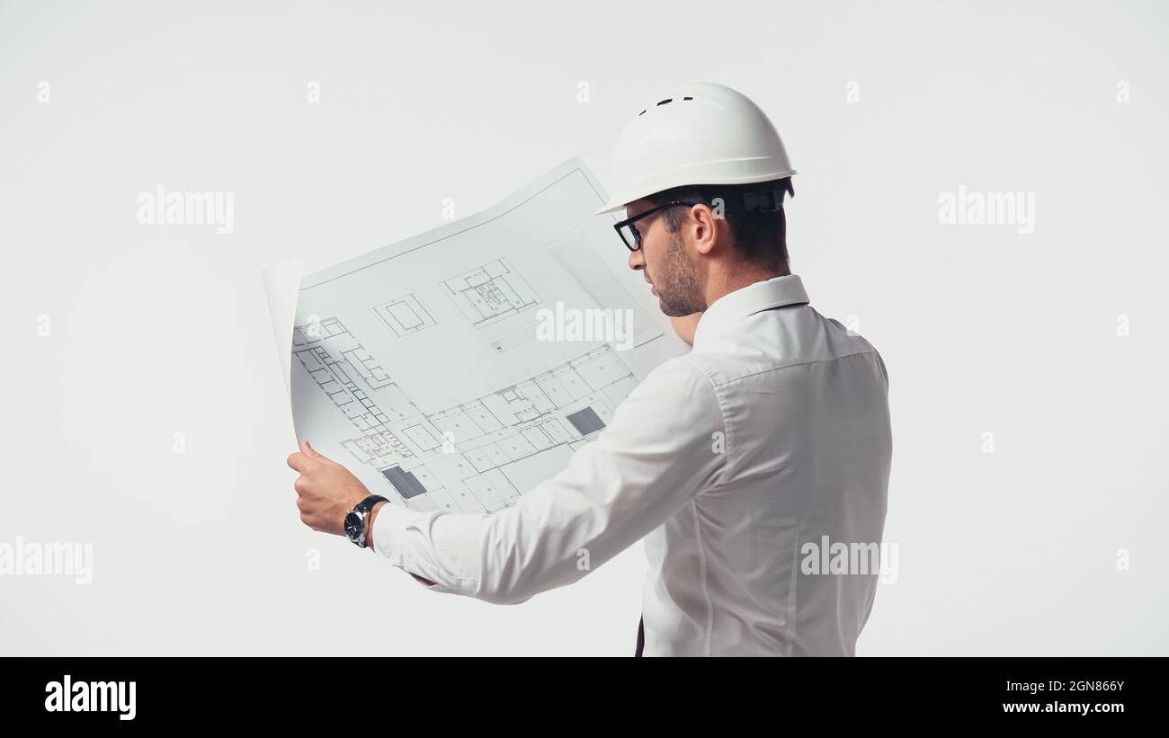 Engineer in helmet looking at blueprint isolated on white Stock Photo ...