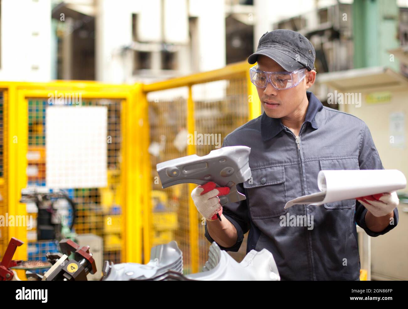 Mechanic worker checking for defects on metal Stock Photo - Alamy