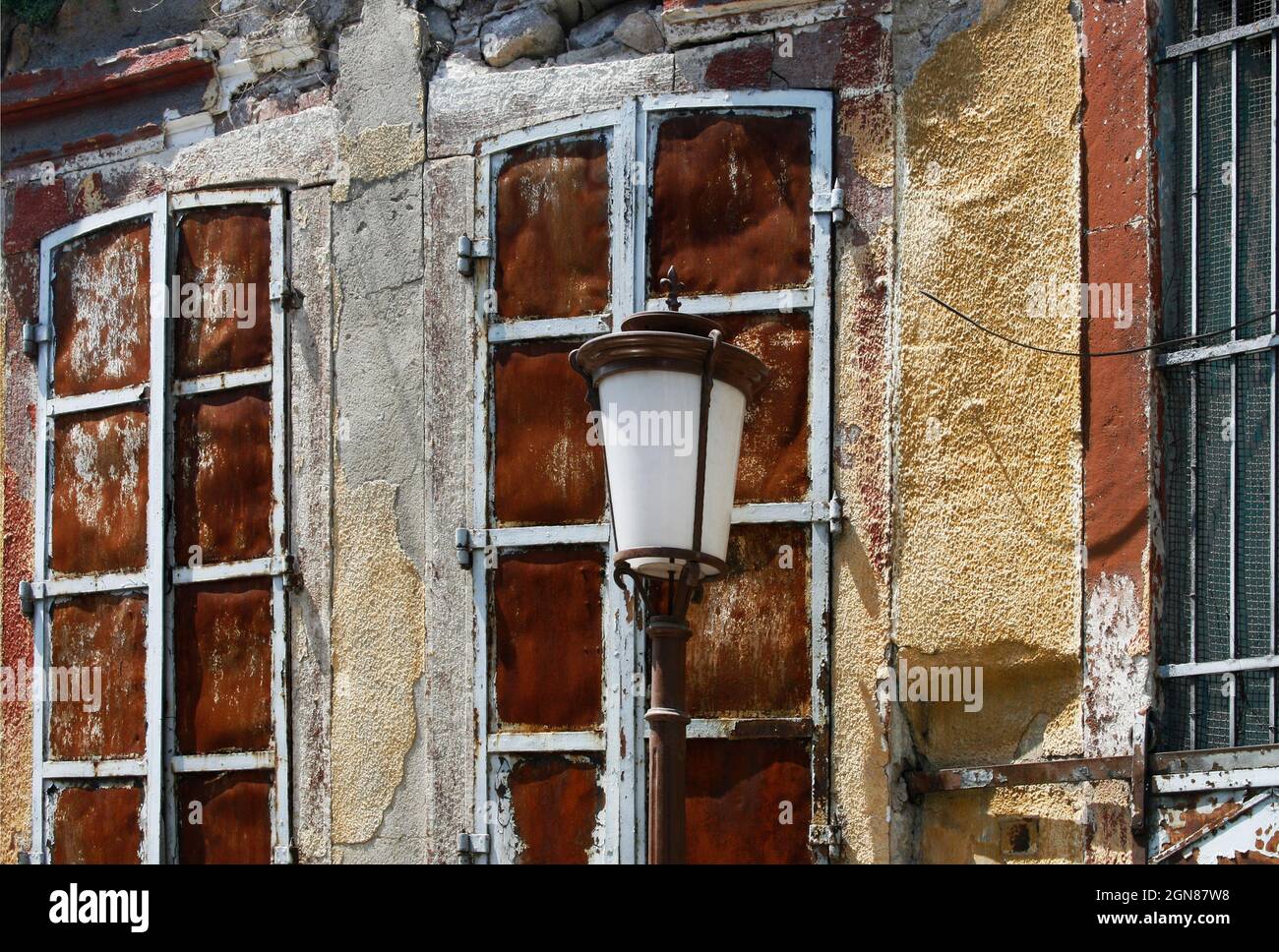 a street light in front of a traditional but abandoned colorful ...