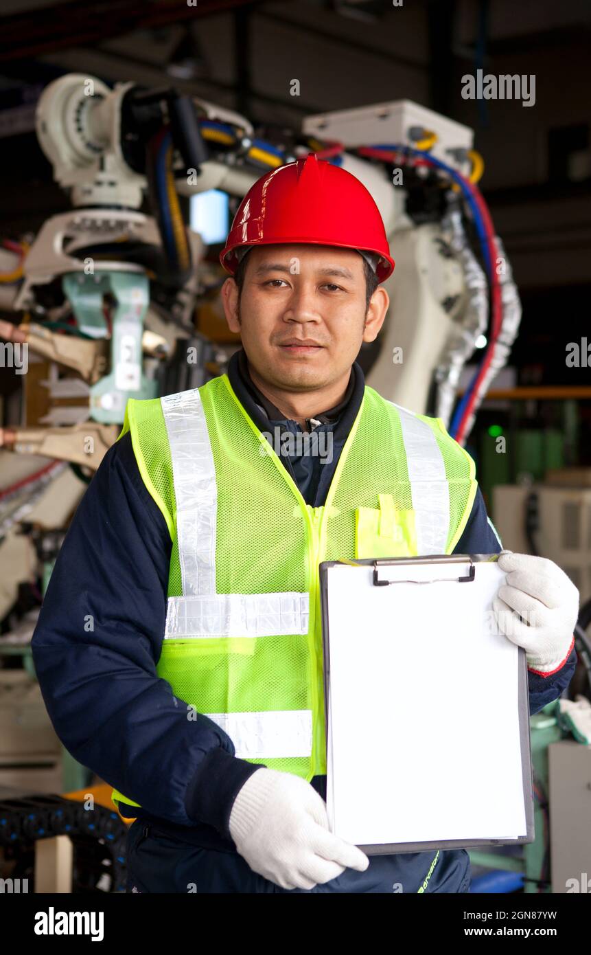 Engineer holding a notepad with robot machine on the bacground Stock ...