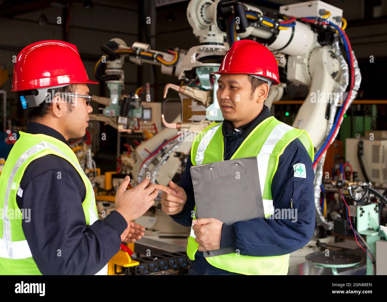 Two workers discussion in factory Stock Photo - Alamy