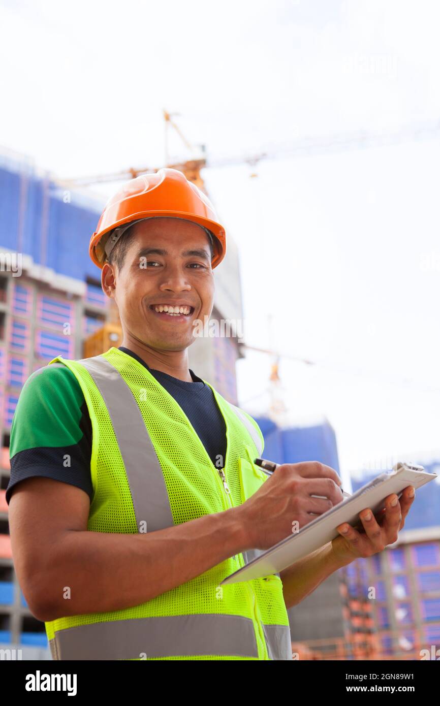 Portrait of young architect holding clipboard against building Stock ...