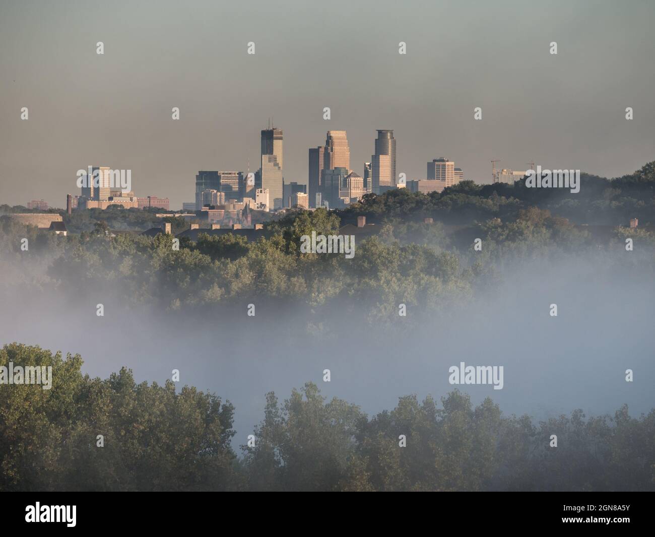 Landscape in morning fog with a cityscape in the back at the start of ...