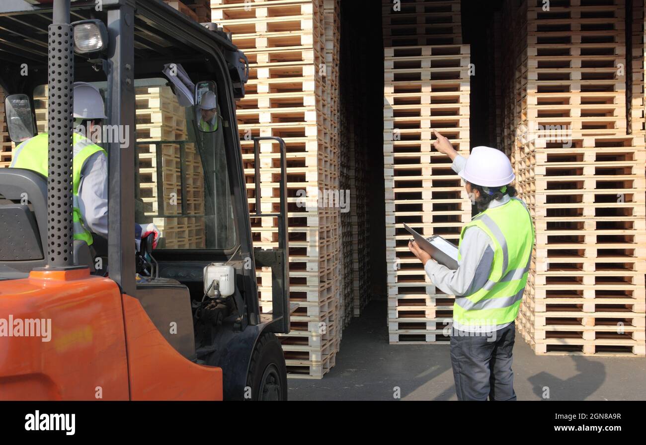 warehouse workers team at unloading works with forklift loader Stock ...