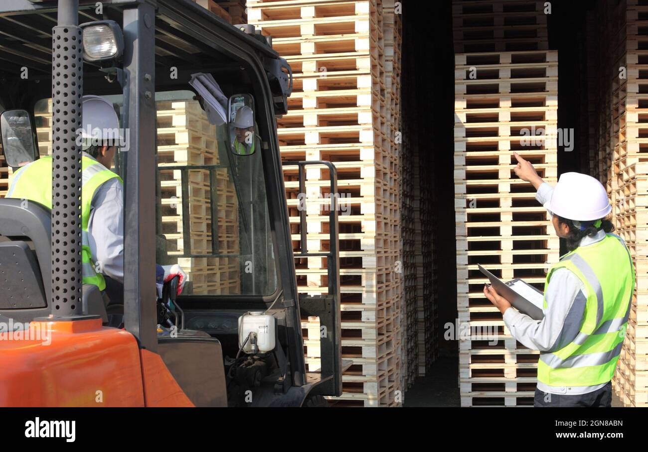 warehouse workers team at unloading works with forklift loader Stock ...